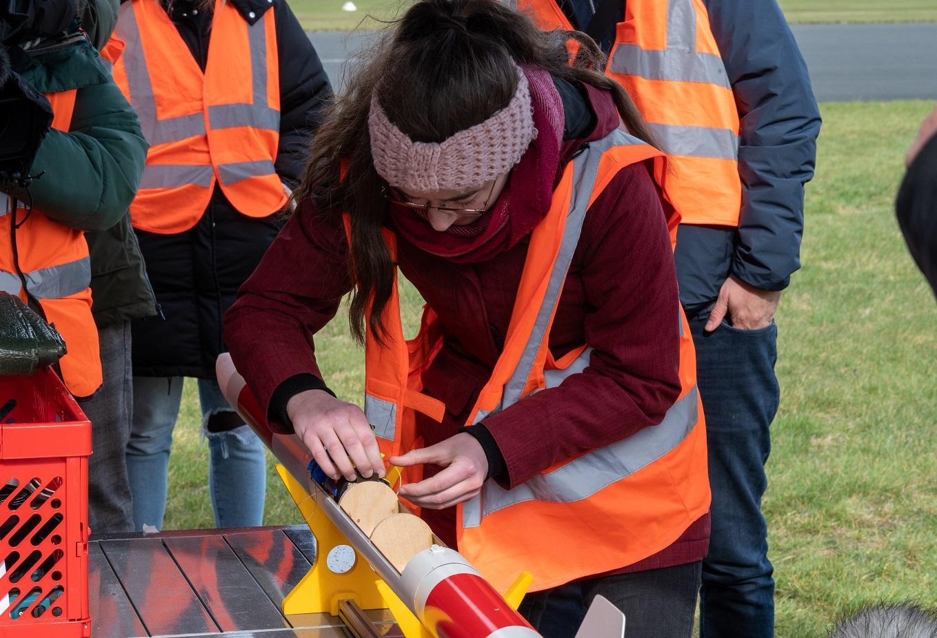 Eine Schülerin bestückt die Rakete mit ihrem CanSat