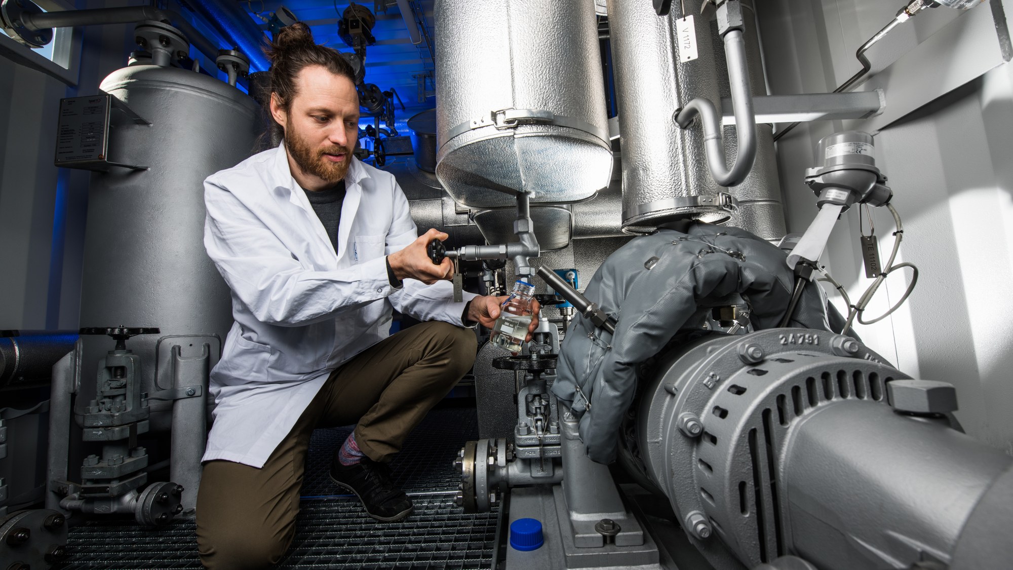 A DLR scientist taking a thermal oil sample