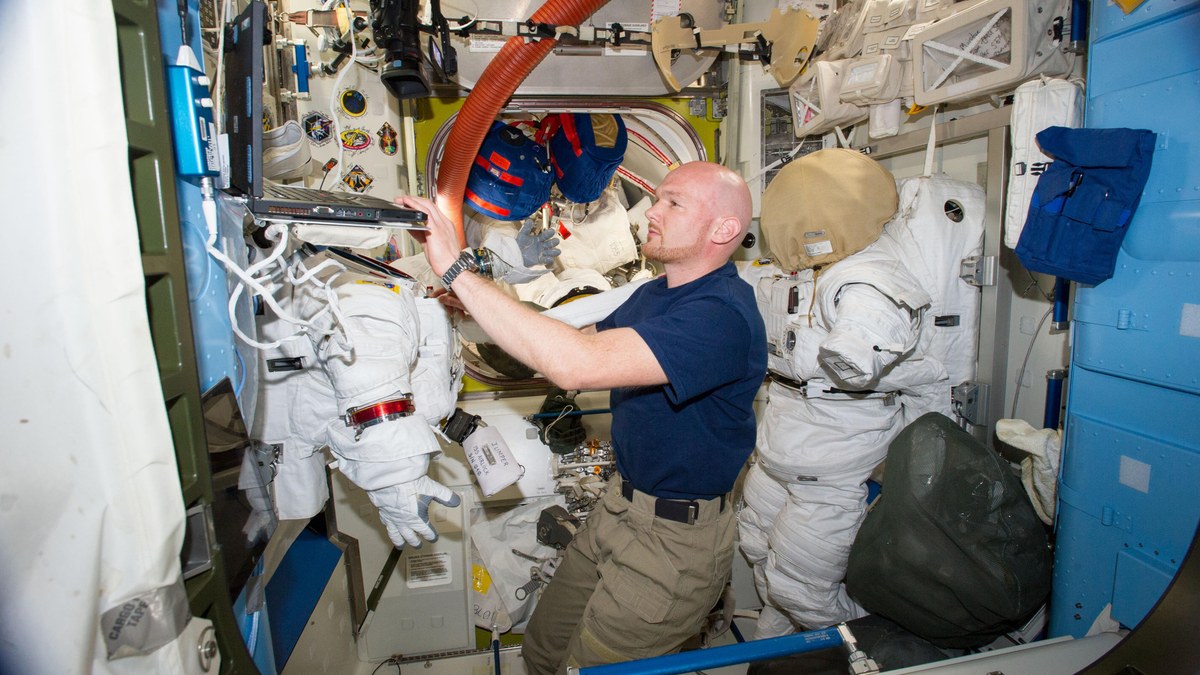 Working on an Extravehicular Mobility Unit (EMU) spacesuit